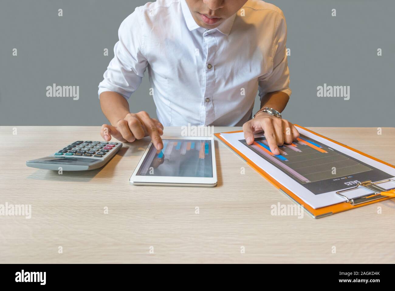 Accountant checking financial number on chart in tablet and document ...