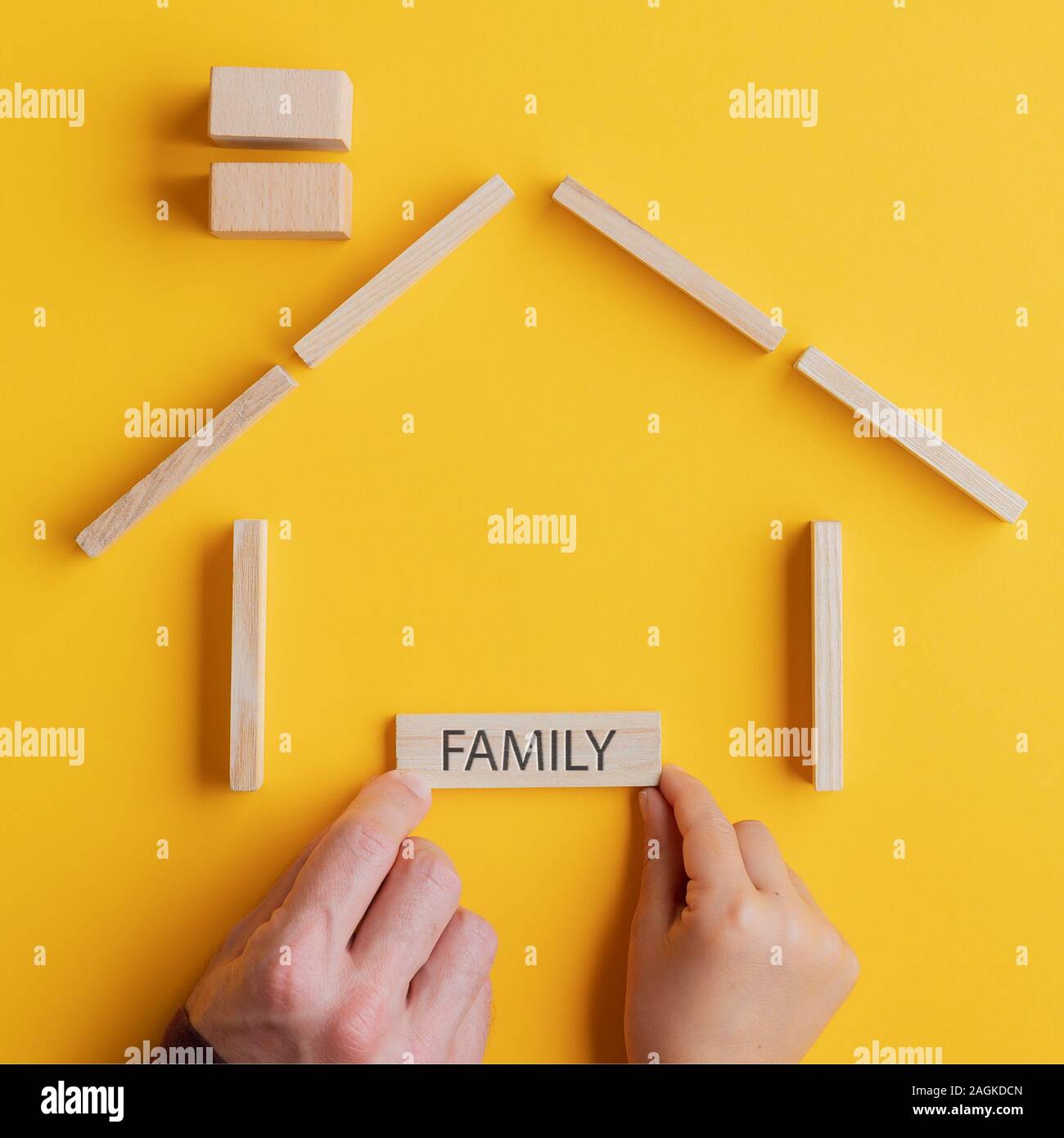 Child and son placing a wooden peg with Family sign on it in a house ...