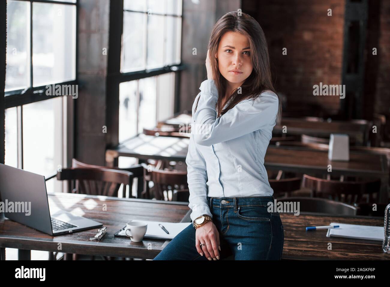 Different stuff on table. Businesswoman in official clothes is indoors ...