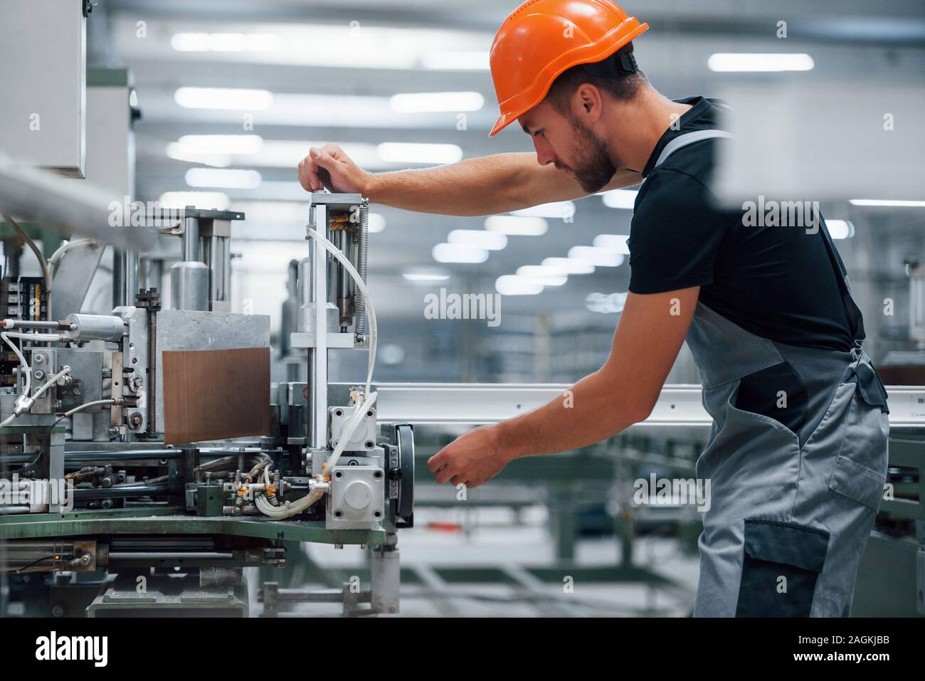 Operator of machine. Industrial worker indoors in factory. Young ...