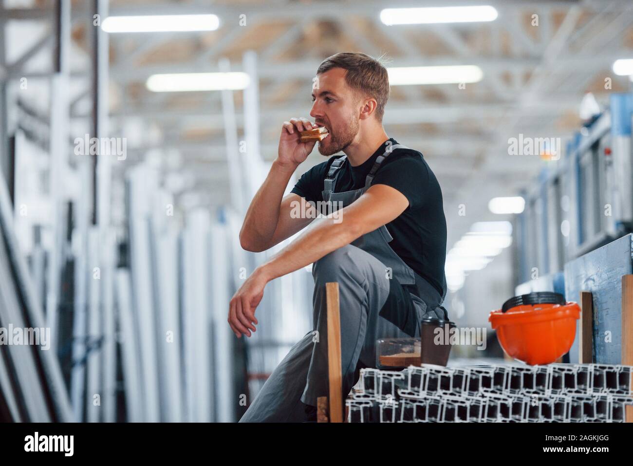 Lunch break. Eating and drinking. Industrial worker indoors in factory ...