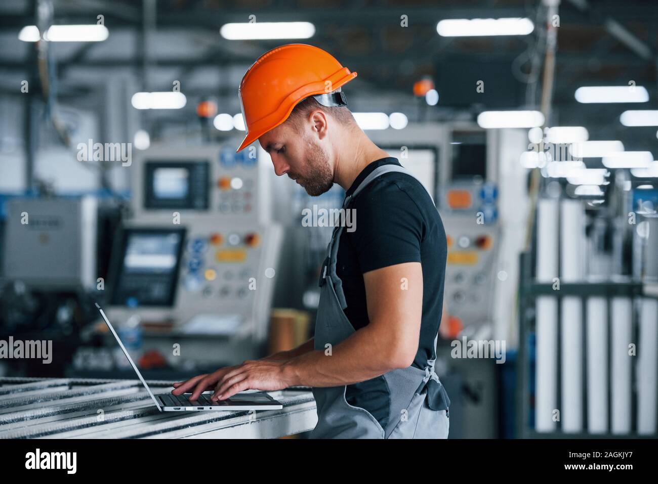 Modern laptop. Typing on keyboard. Industrial worker indoors in factory ...