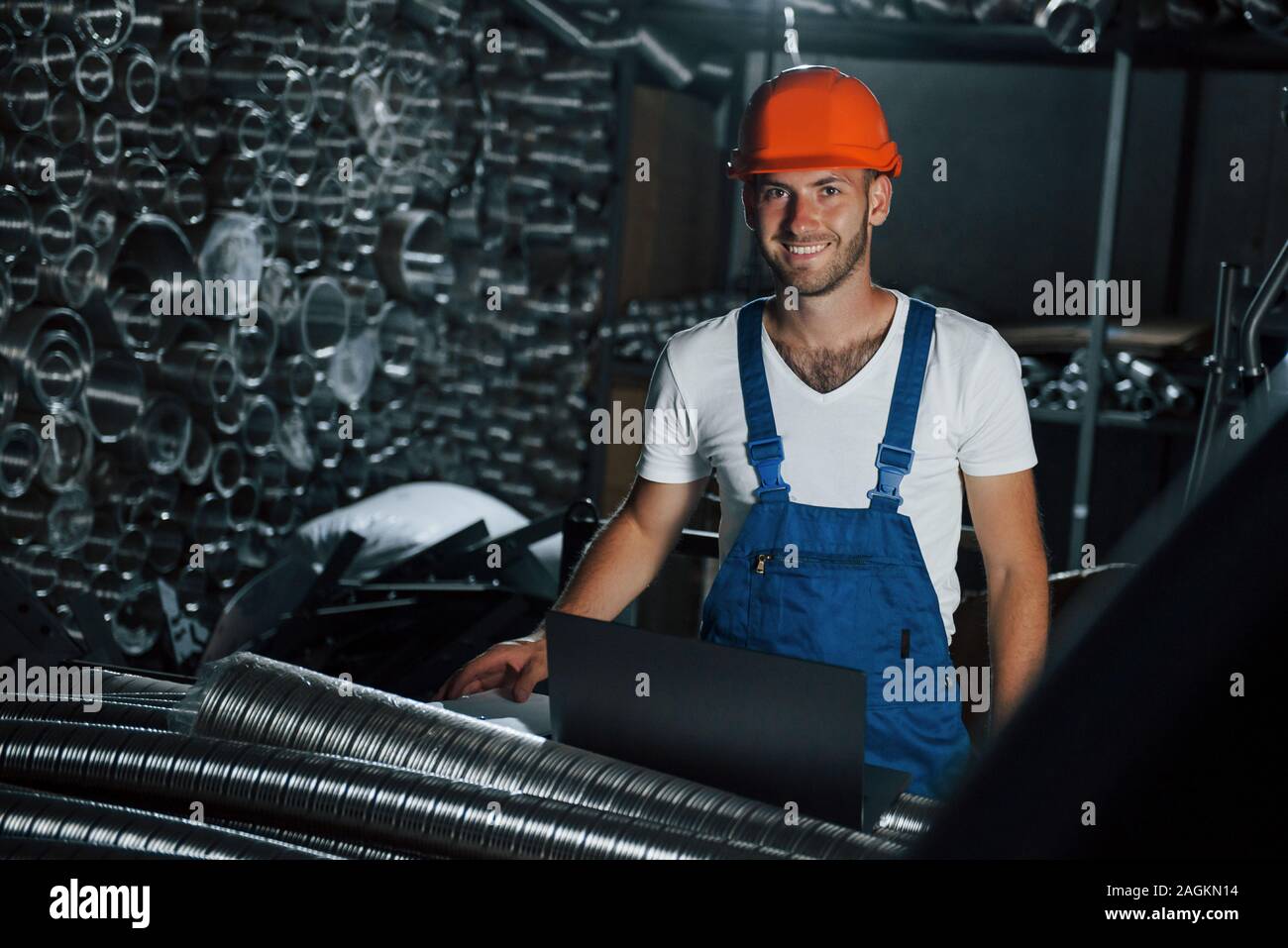 Positive mood. Man in uniform works on the production. Industrial ...
