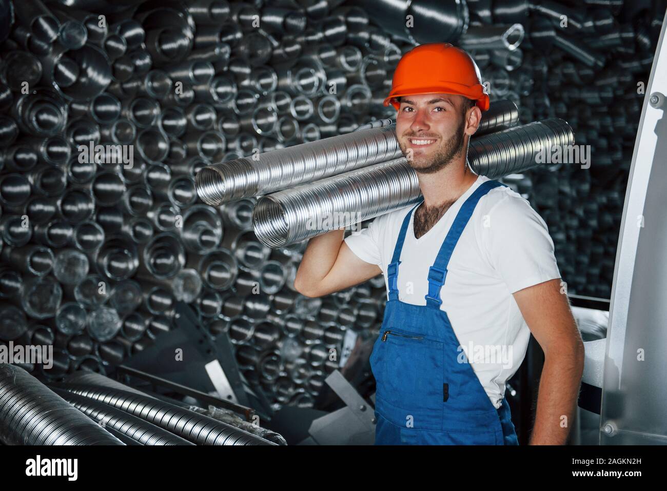 Cheerful mood. Man in uniform works on the production. Industrial ...