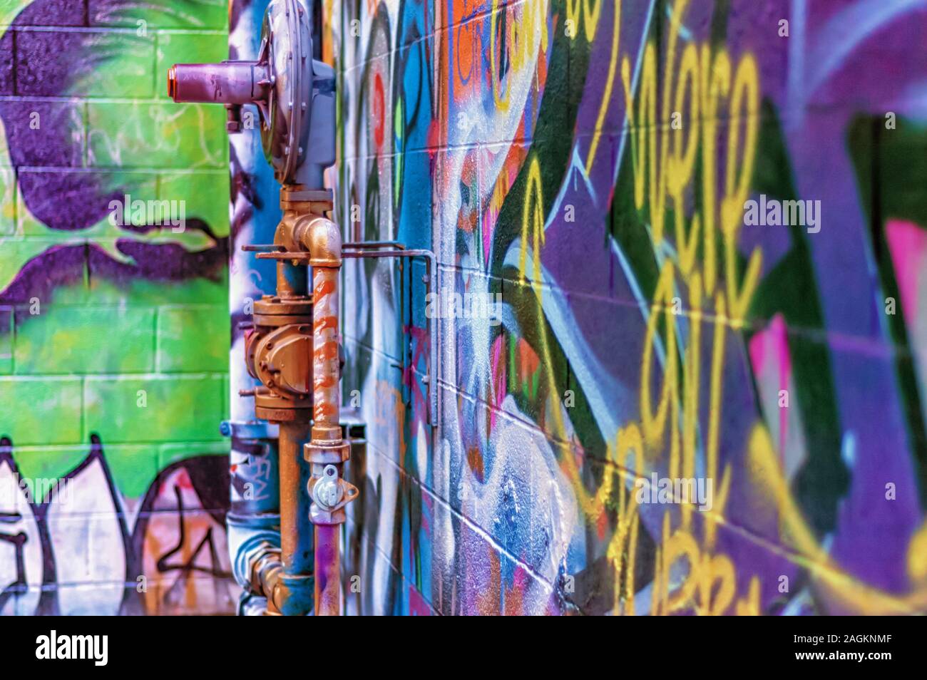 Graffiti adorned wall and a pressure valve at tripper's alley or poet's ...