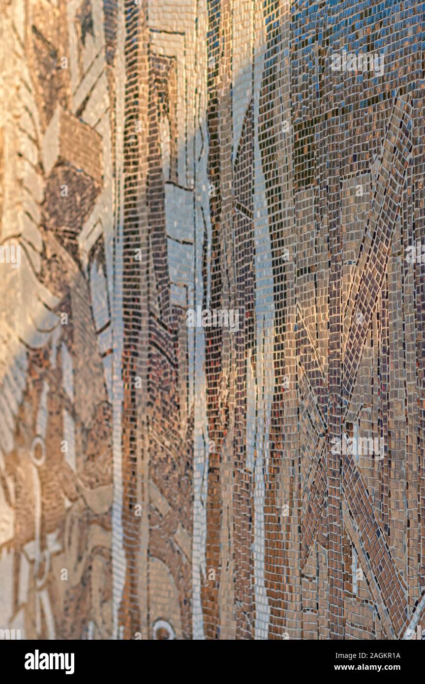 A shallow depth of field photograph of a tiled wall displaying a mural ...