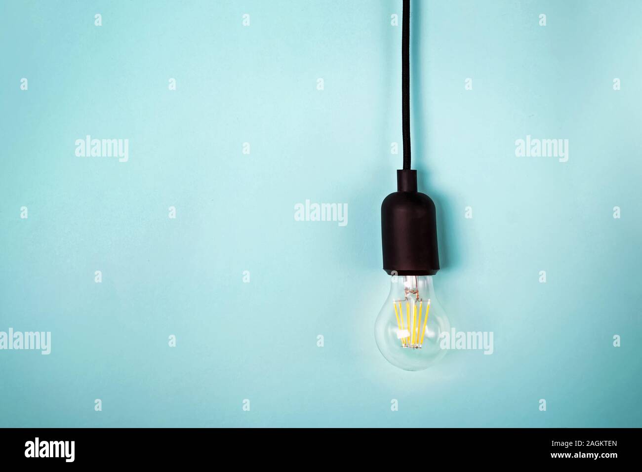 Retro electric light bulb with cord isolated on turquoise color ...