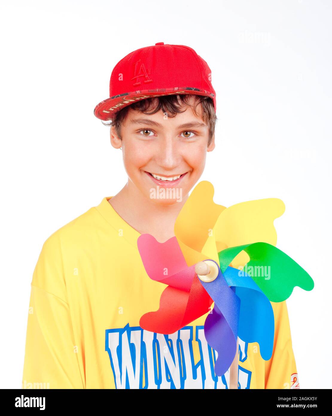 teenage boy in red baseball cap holding a pinwheel -isolated on white ...