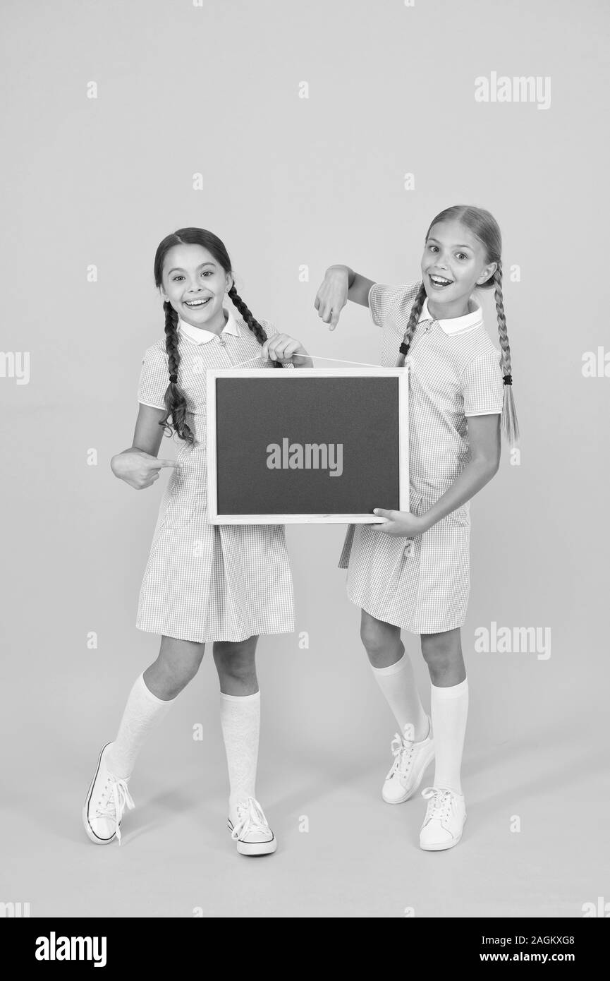 School news. True information. Little girls hold writing surface yellow ...