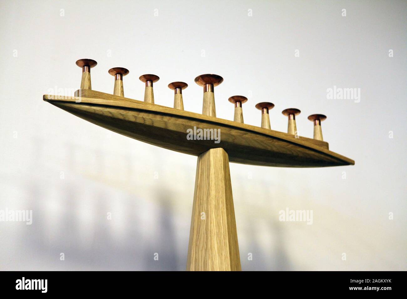 A wooden Jewish menorah taken from below at angle against white ...
