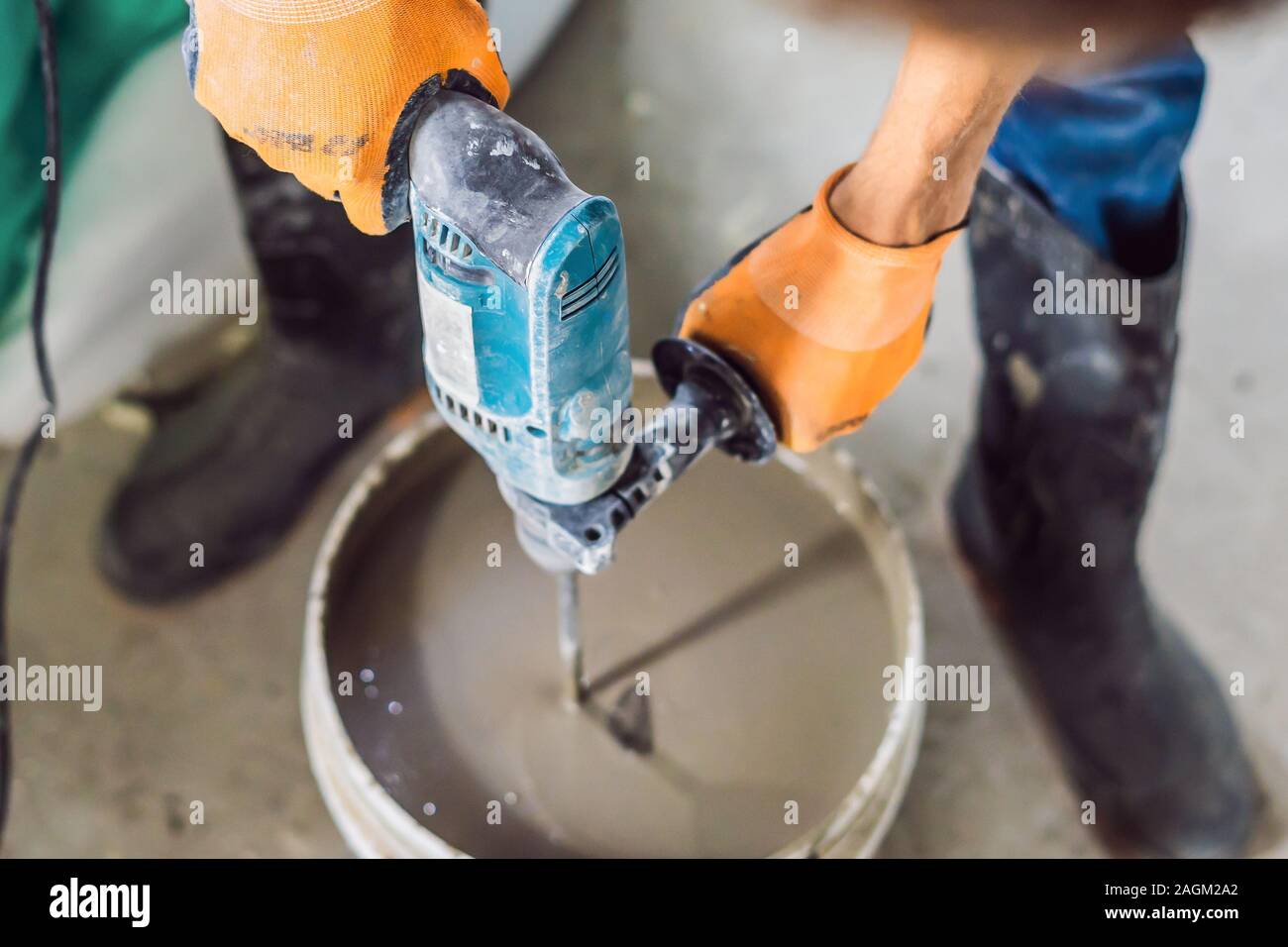 Person mixing cement in bucket hi-res stock photography and images - Alamy