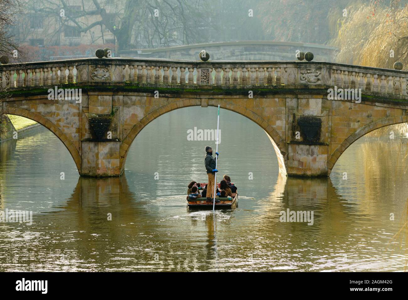 A punt on the River Cam going under Clare College bridge in Cambridge ...
