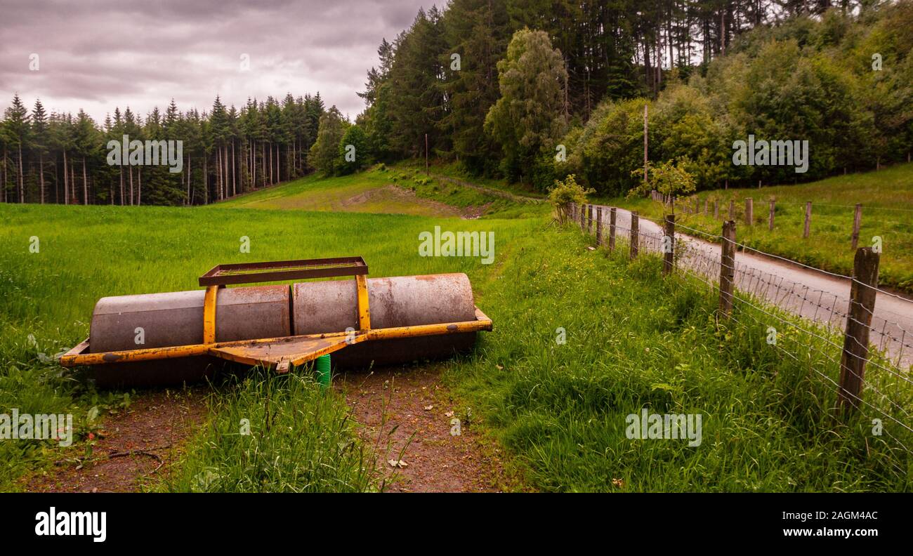 A farm roller sits in a field beside Logierait Woods on hills above the ...