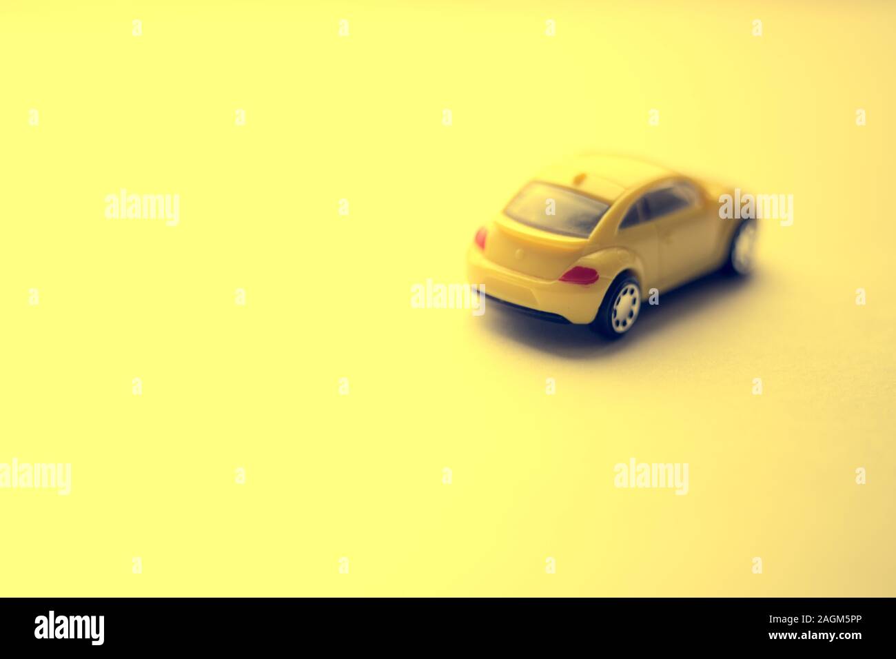 Unfocused yellow toy car on the yellow space Stock Photo - Alamy