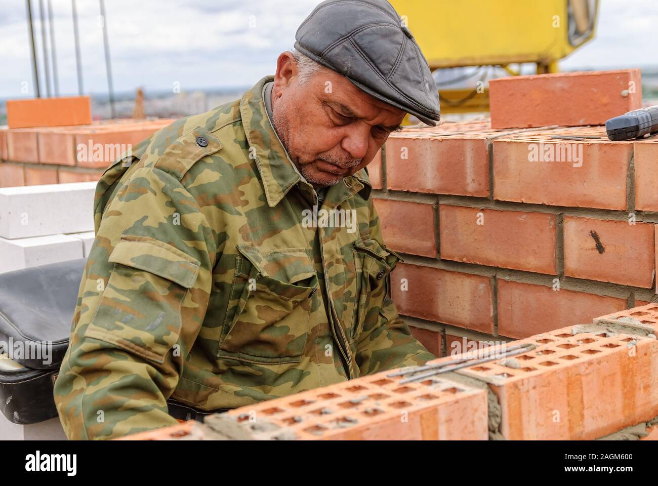 Elderly bricklayer works on house construction Stock Photo - Alamy