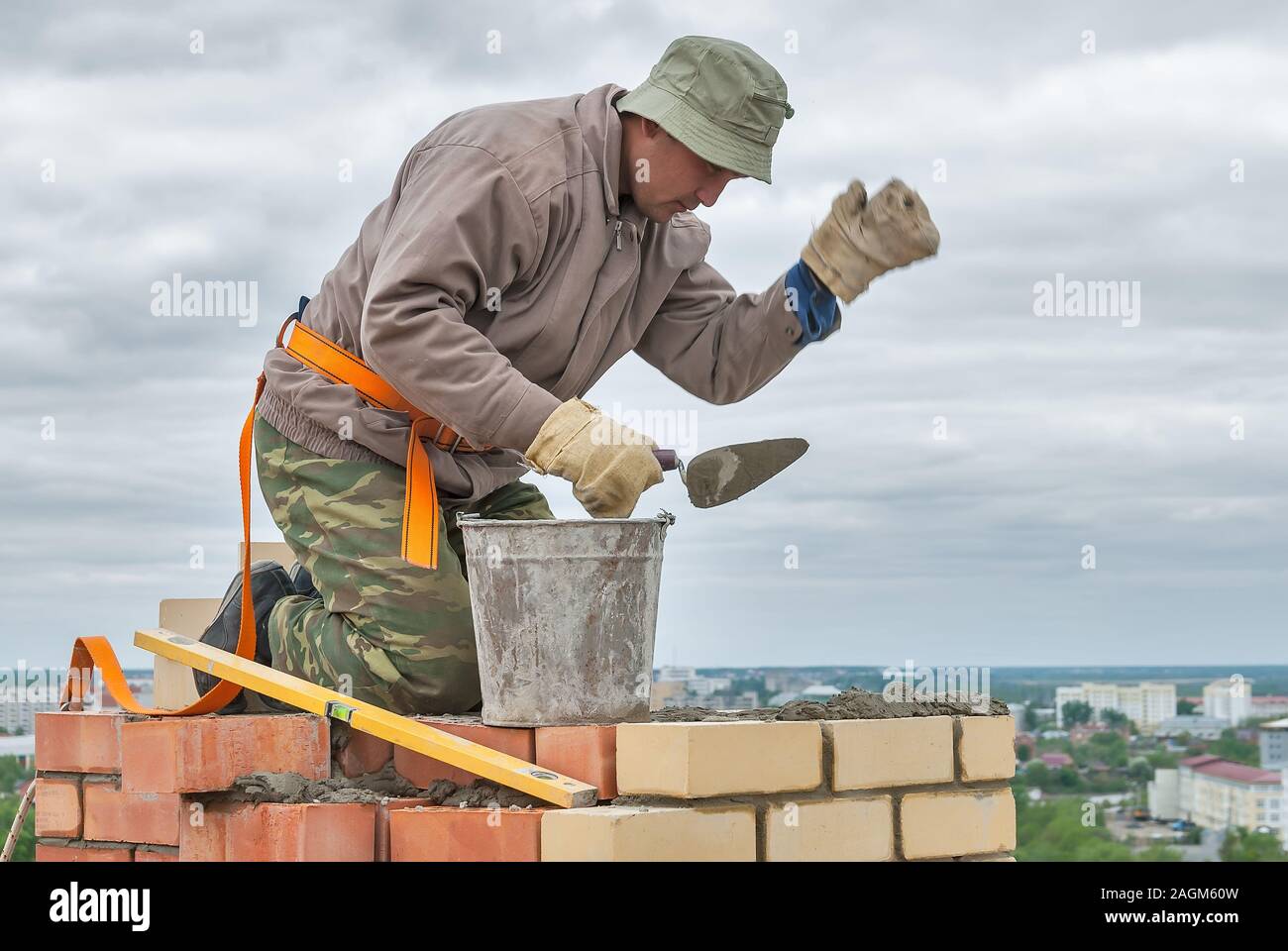 Bricklayer works on 15th floor of building Stock Photo - Alamy