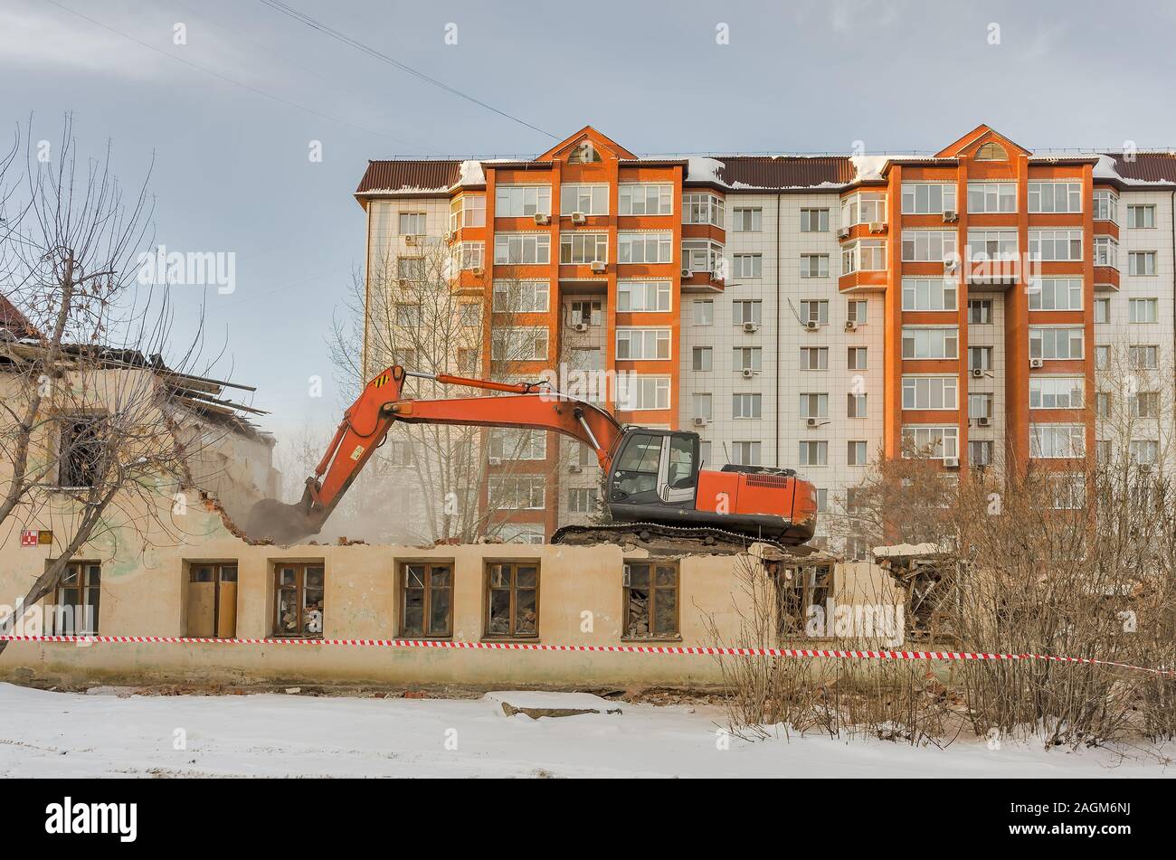 Demolition of a house with an orange digger Stock Photo - Alamy