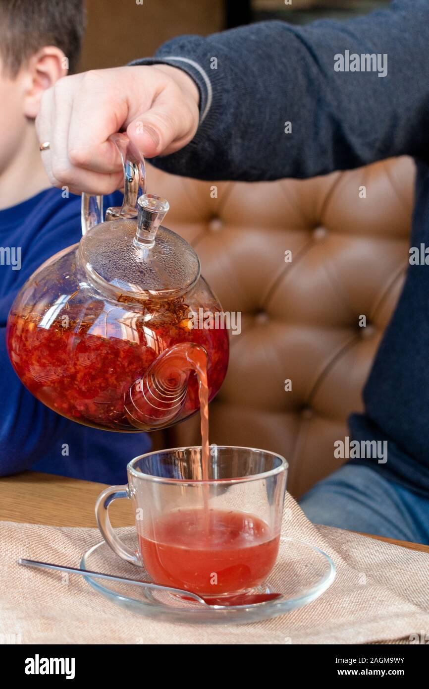 Male hand pours red tea from a teapot into a cup Stock Photo - Alamy