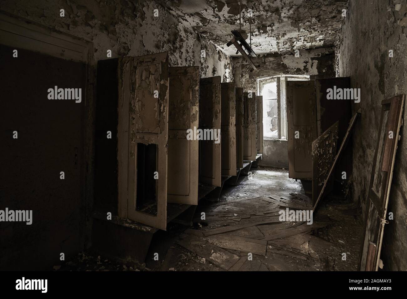 Interior shot of an old abandoned building with rusted wooden doors ...