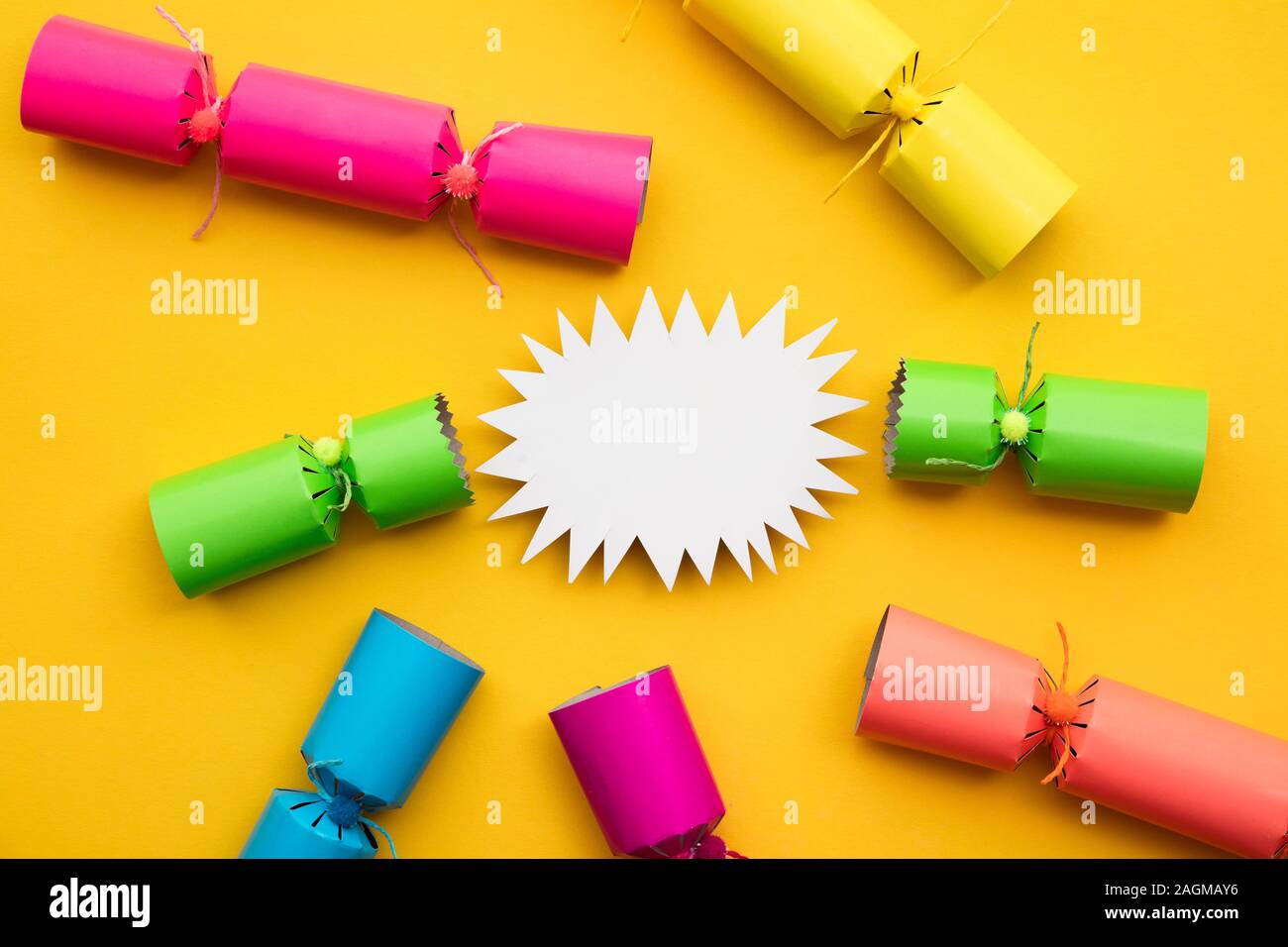 Popped Christmas crackers on a yellow background Stock Photo - Alamy