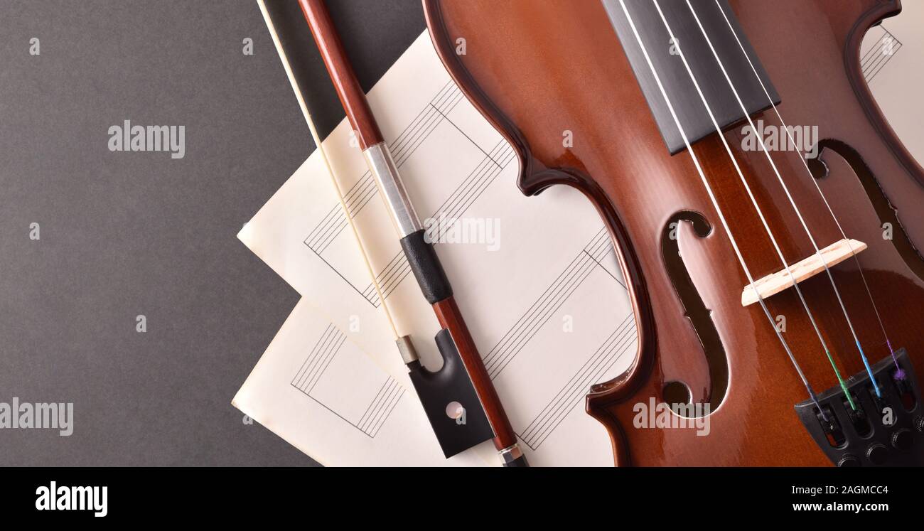 Violin body and bow with sheet music on black table. Top view ...
