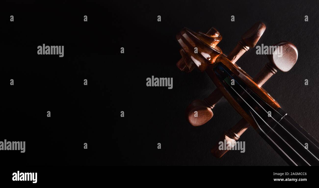 Violin pegbox and bow on black textured table Top view. Horizontal ...