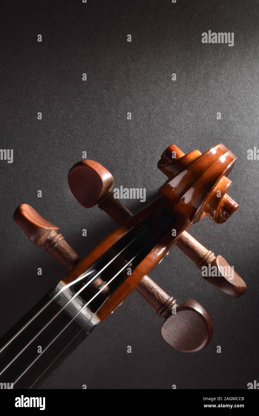 Violin pegbox and bow on black textured table Top view. Vertical ...