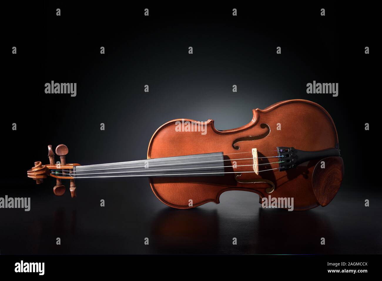 Violin reflected on wooden table and black gradient background ...