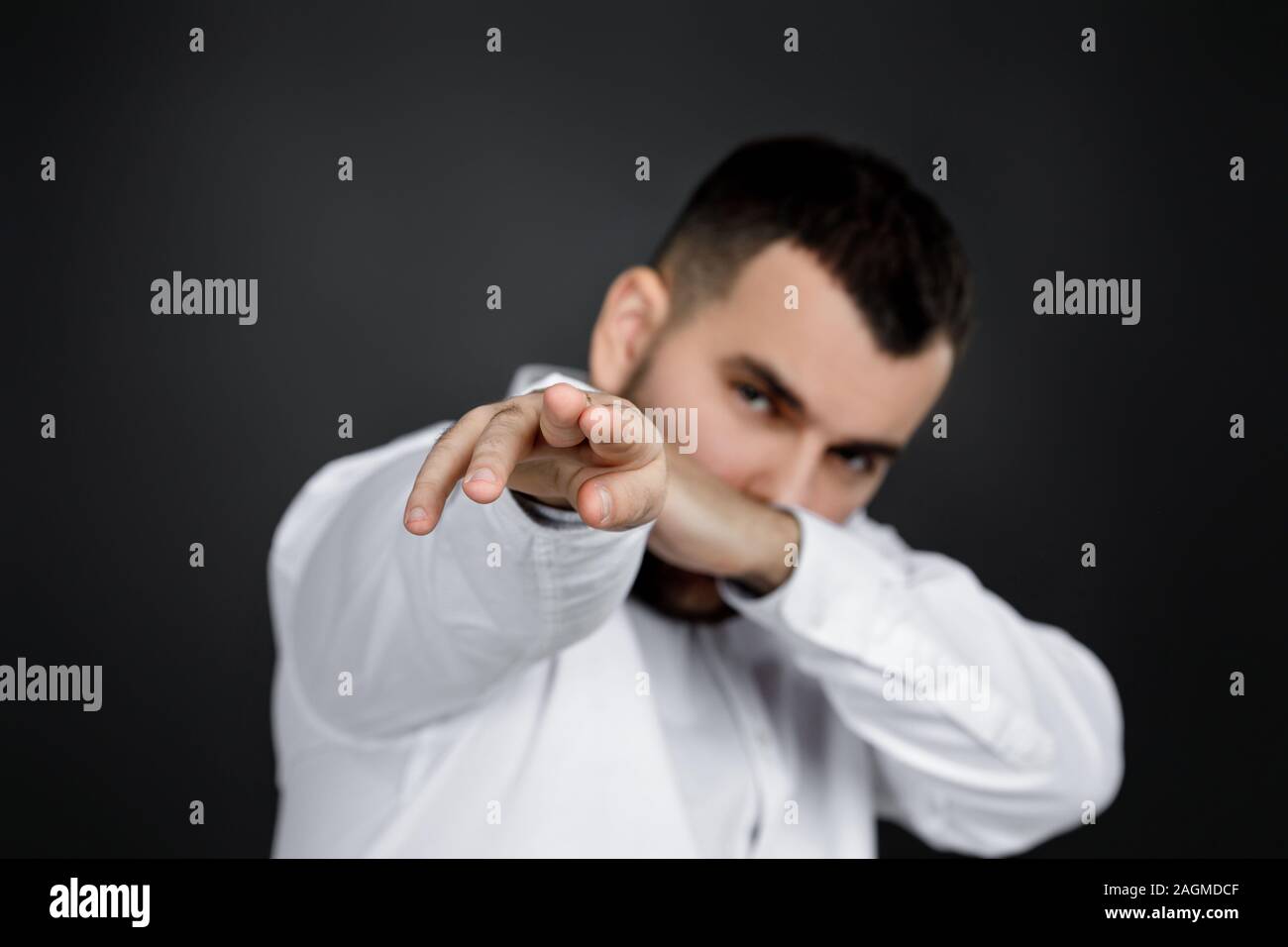 young man points hand at you on black background. focus on hand. man ...
