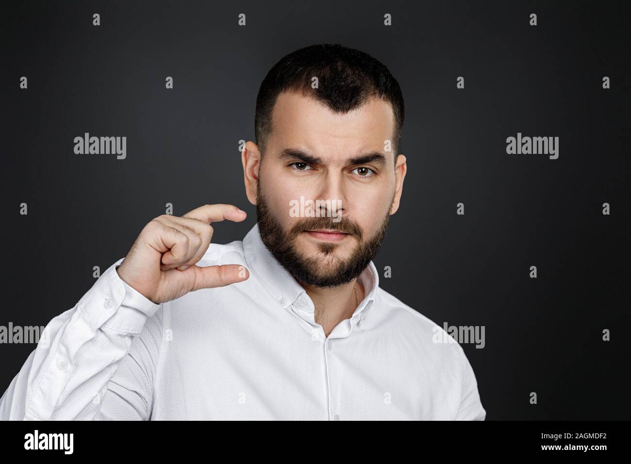 handsome bearded man holding two hands in front of him showing small ...