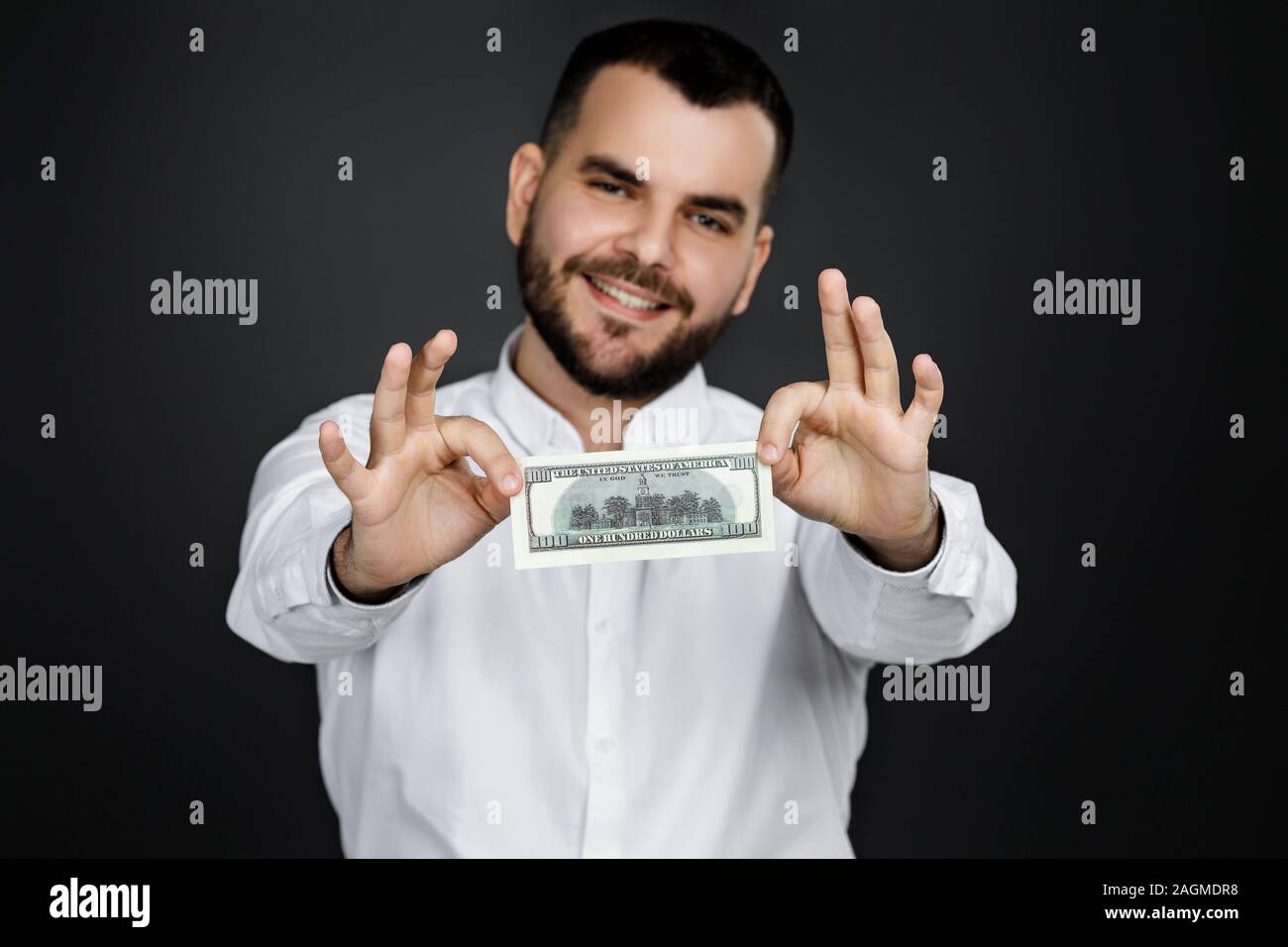 Portrait of young man holding money banknotes isolated on black ...