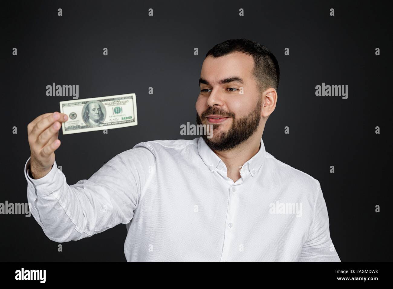 Portrait of young man holding money banknotes isolated on black ...
