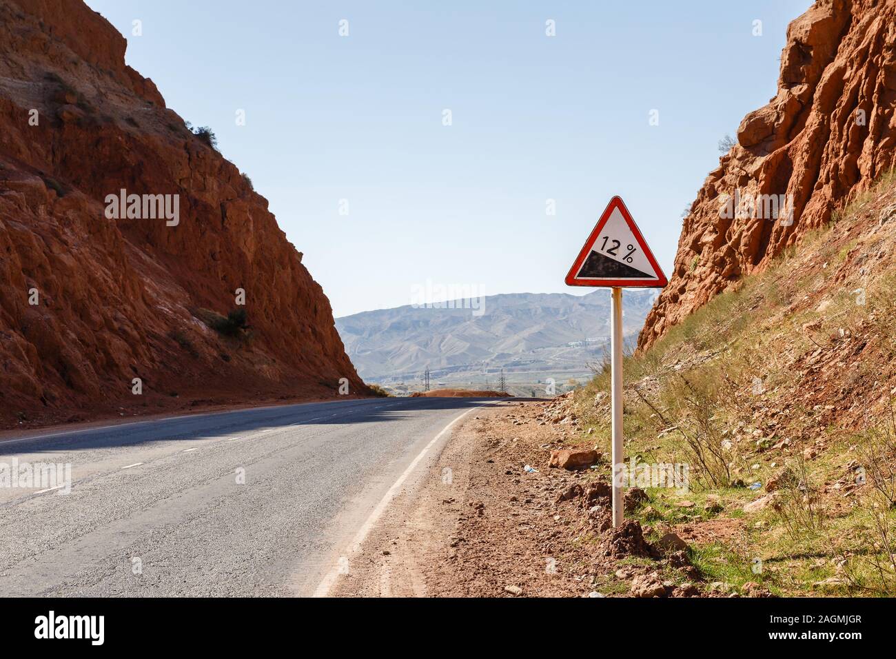 Downhill road sign with percentage on a mountain road, warning traffic ...