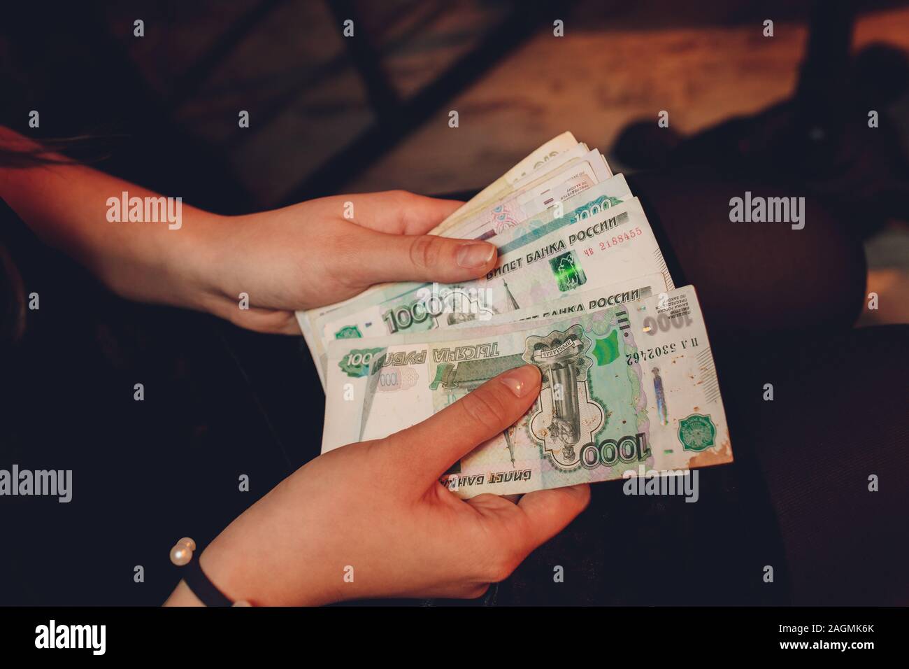 Rubles in hands. Stack of money. Black background Stock Photo - Alamy