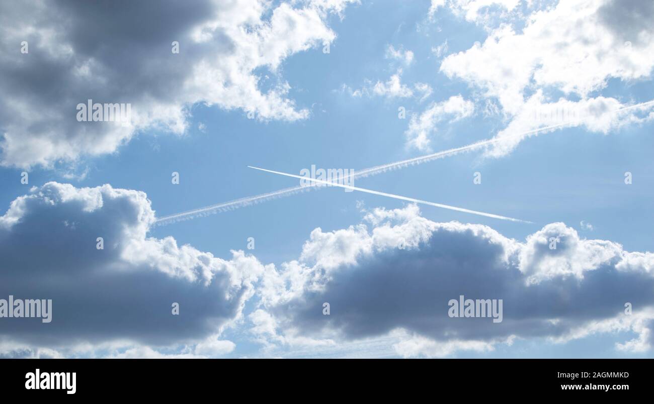 Two passenger plane trails cross in the sky, making it look like a ...
