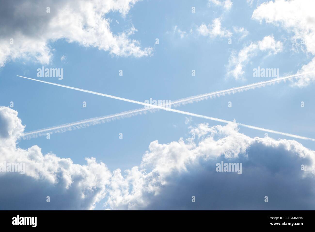Two passenger plane trails cross in the sky, making it look like a ...