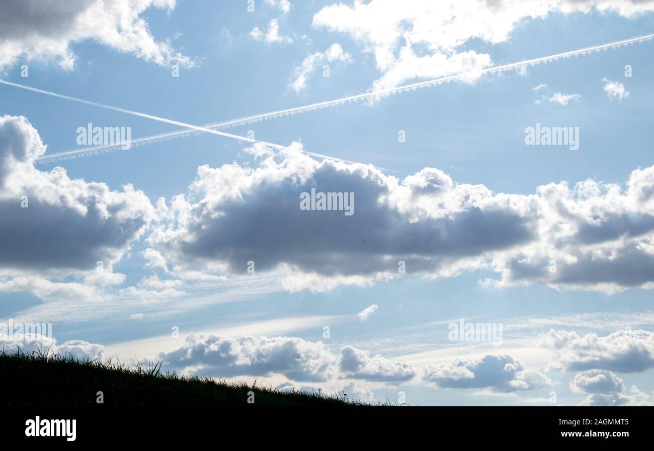 Two passenger plane trails cross in the sky, making it look like a ...