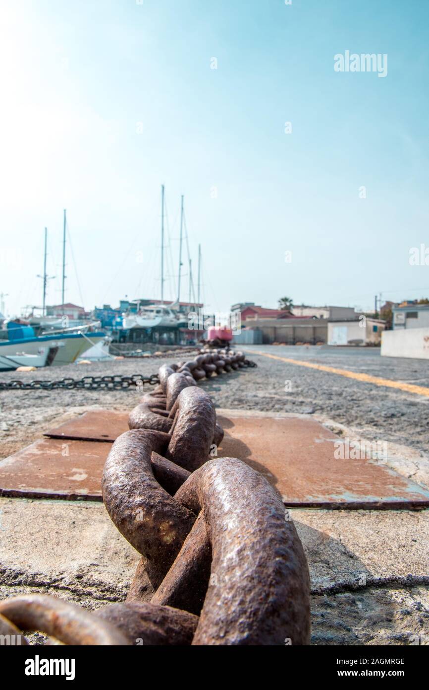 A view from the ground looking alone harbor wall chains Stock Photo - Alamy