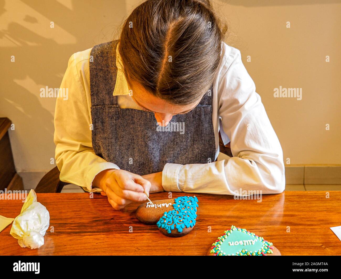 Woman adds name to gingerbread cookie in medieval town of Torun, Poland ...