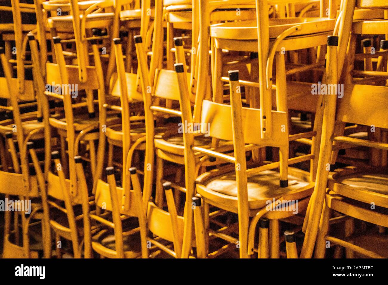 A large stack of wooden chairs in a church Stock Photo - Alamy