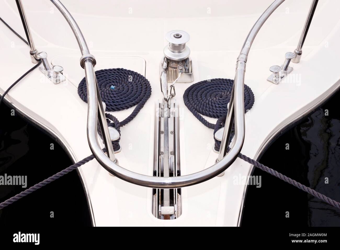 Bow of a moored yacht with two coiled blue ropes Stock Photo - Alamy