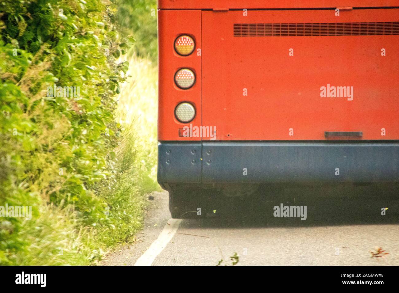 A bus traveling down a country road, the dust etc being lifted at the ...