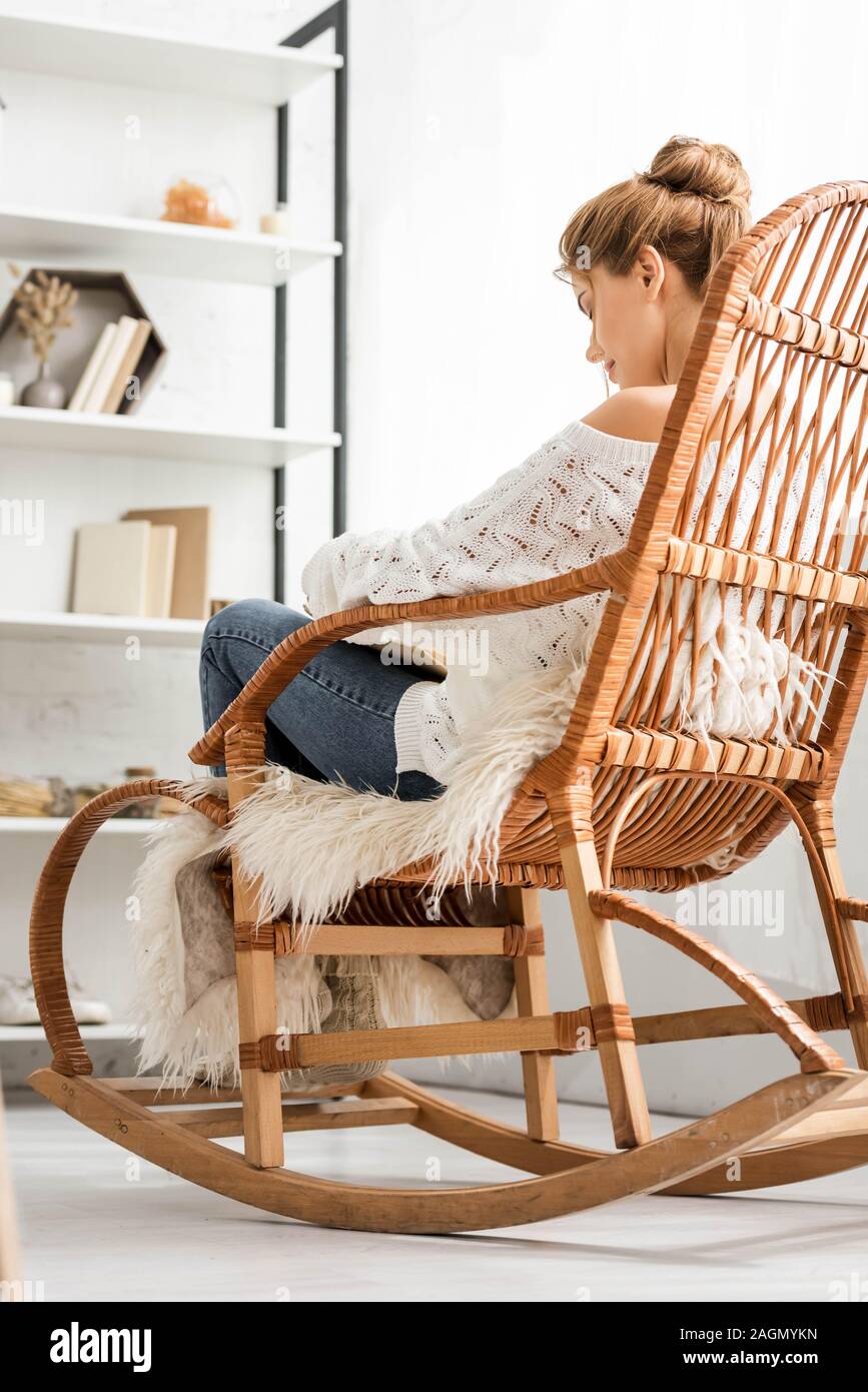 back view of woman in white sweater sitting on rocking chair Stock ...