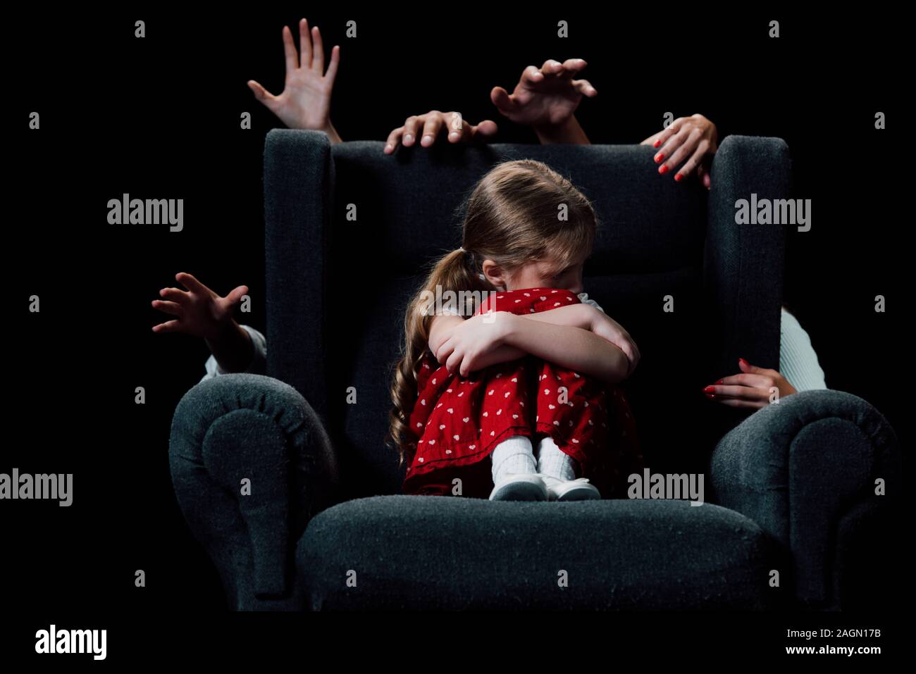 scared child sitting in armchair surrounded with human hands isolated ...