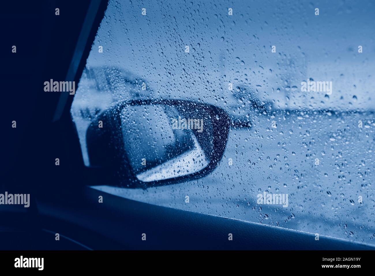 Blurry wet abstract glass background. Rear back view car mirror with ...