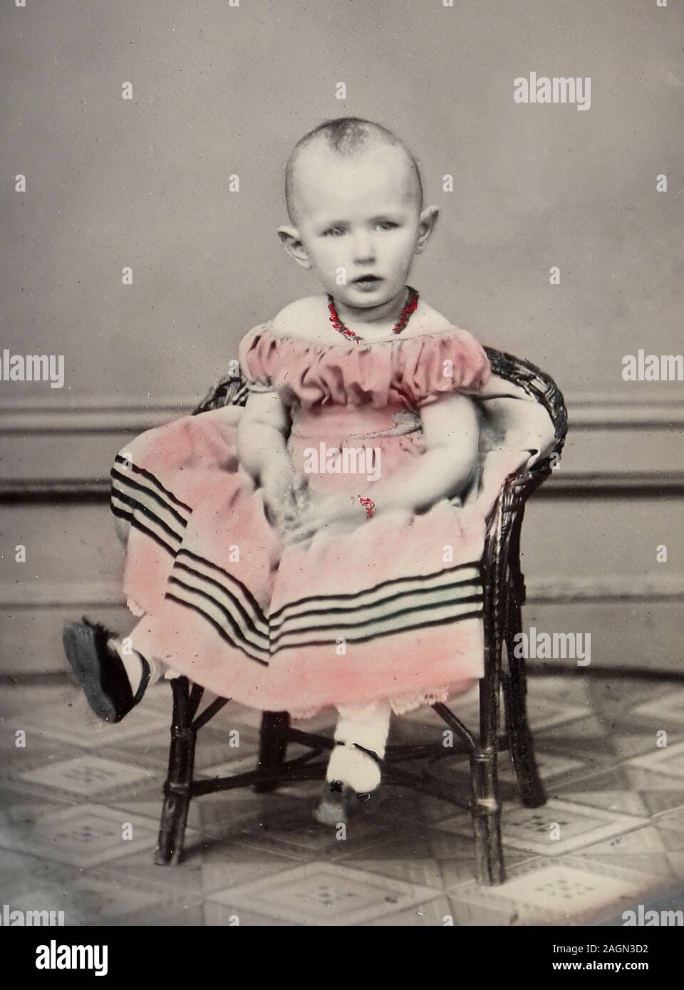 A tiny young girl sits for a tinted ambrotype portrait, ca. 1860 Stock ...