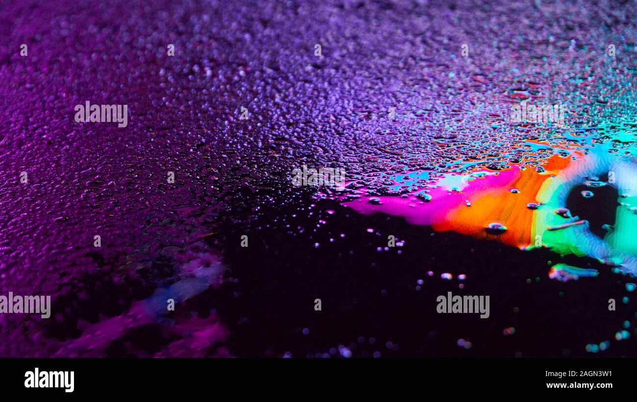 Wet asphalt at night with puddle and colorful reflecting lights Stock ...