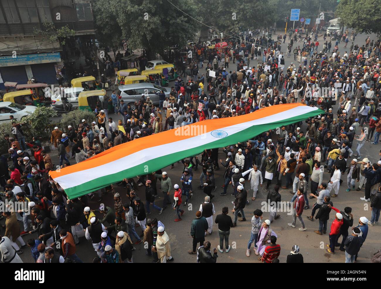 Crowd of protesters marching with a large Indian flag during the ...