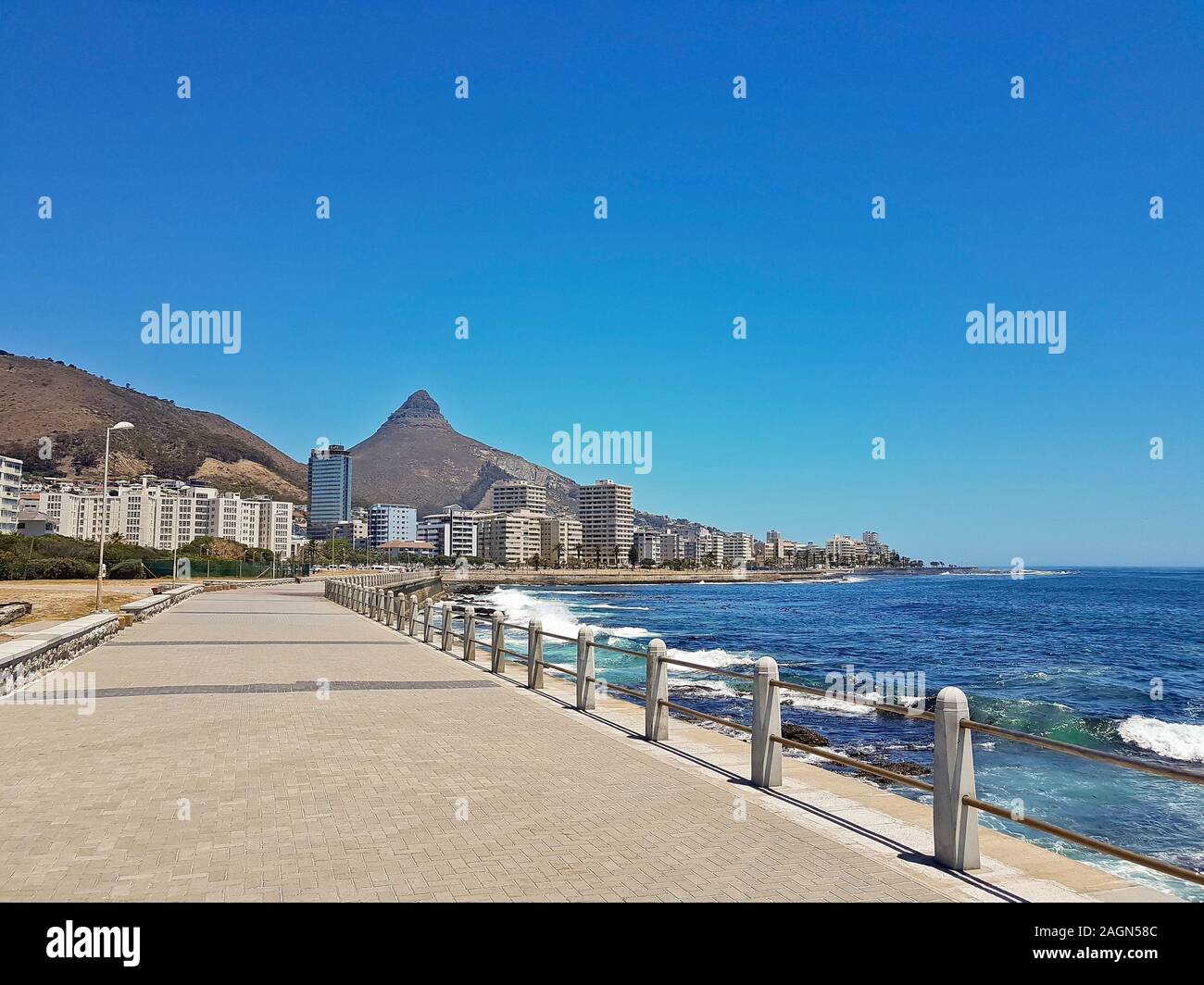 Mountains, hotels and deep blue water with waves at the Sea Point ...