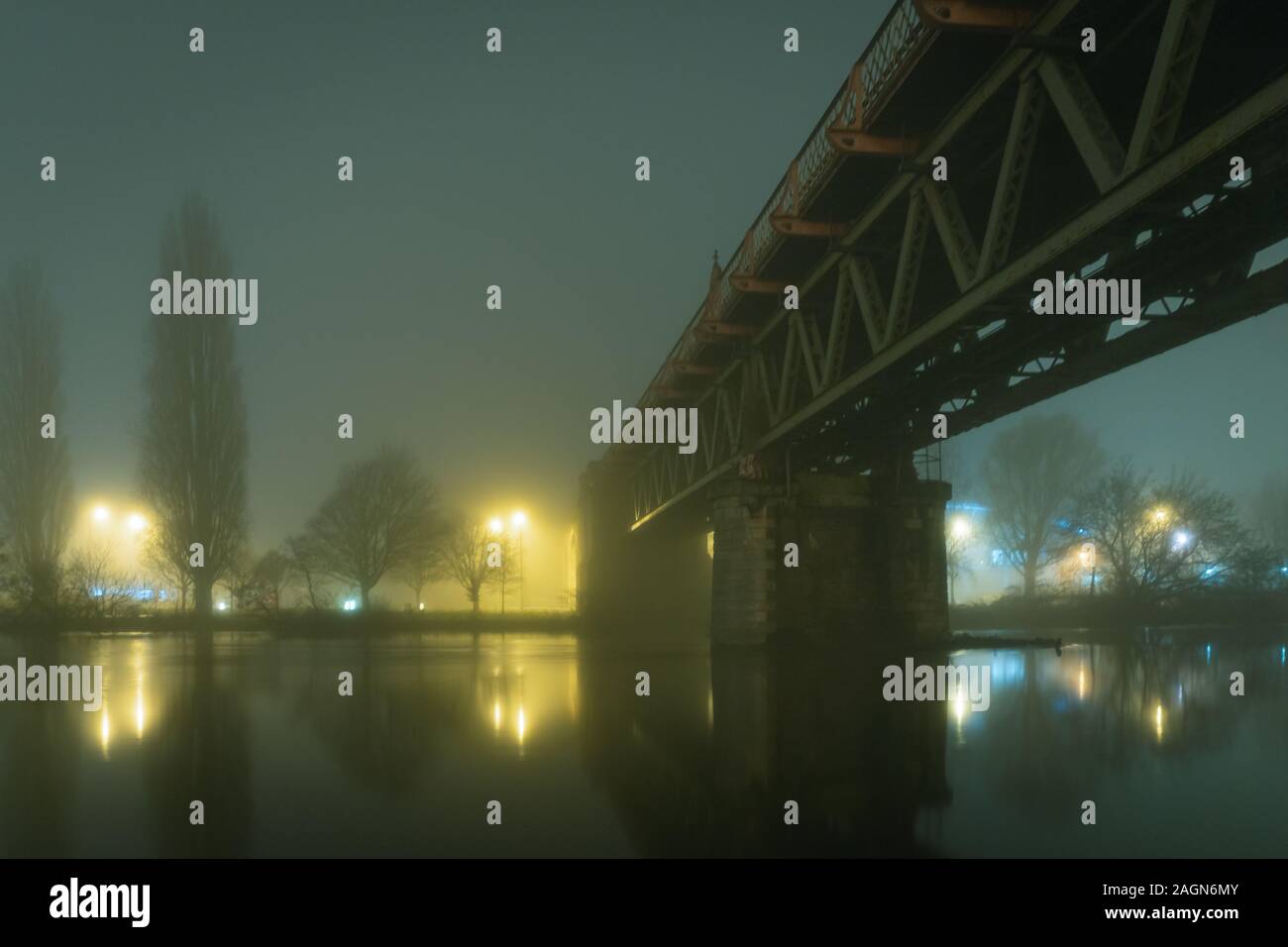 A Victorian steel railway bridge going over a river on a moody ...